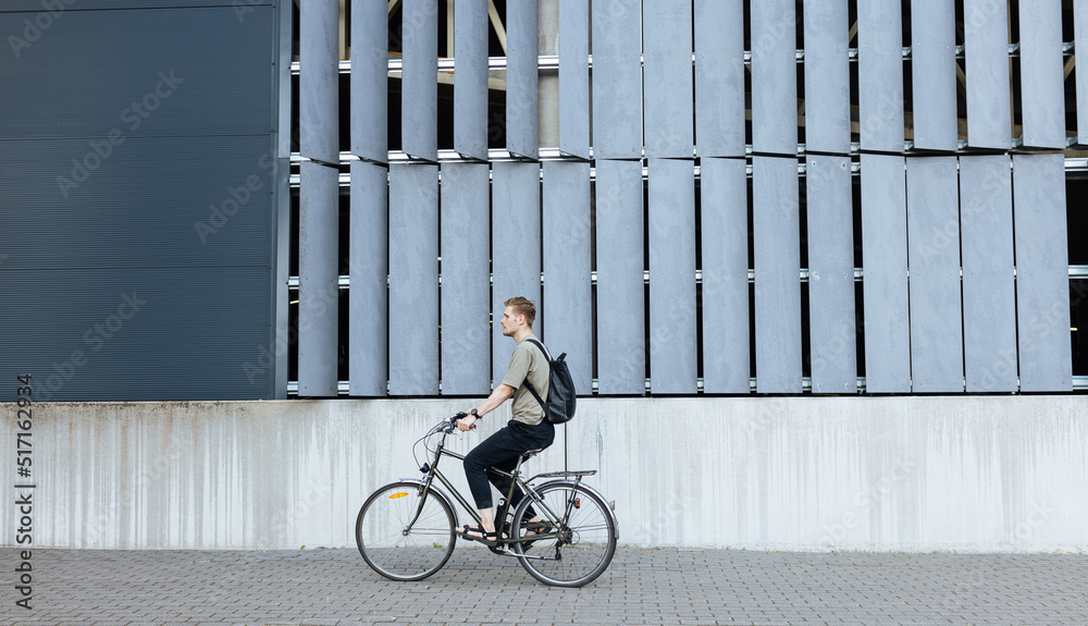 Young man riding a bike. Sustainable micro mobility transport New way ...