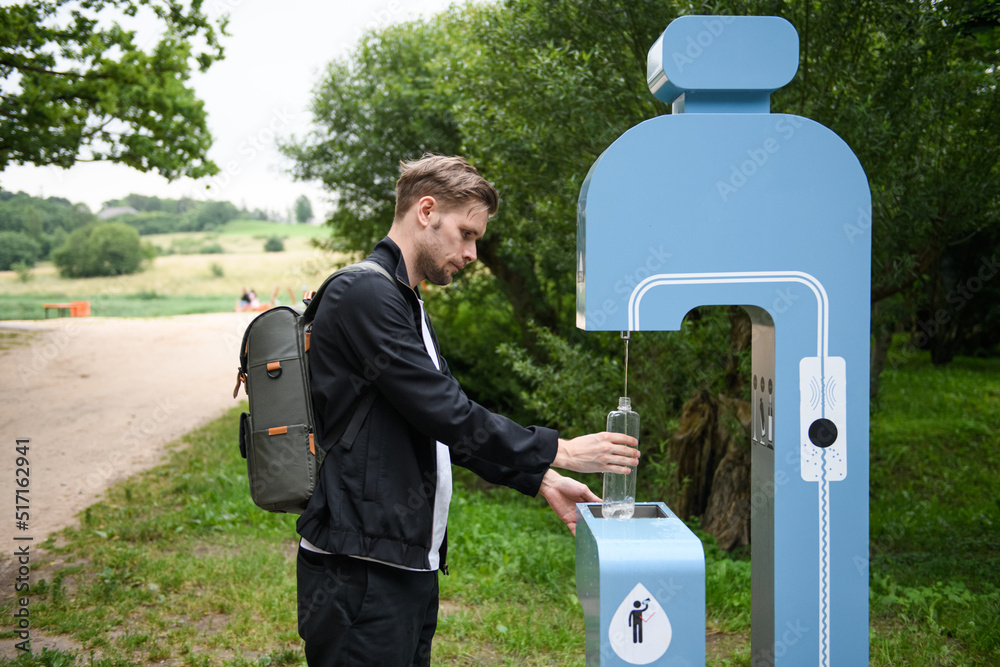 Man refilling his water bottle at the city. Free public water bottle ...