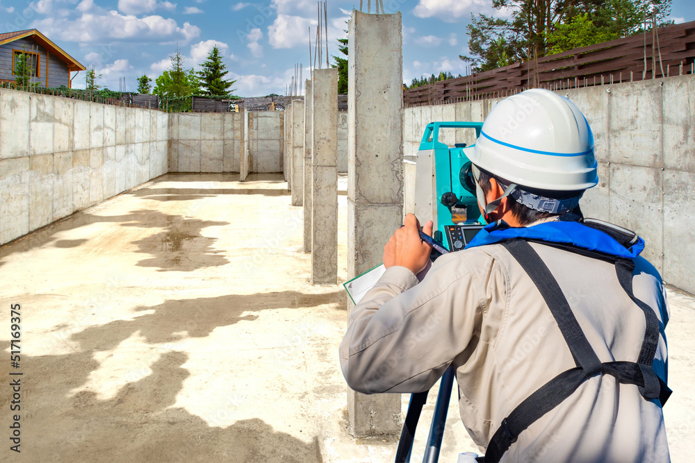 Surveyor at construction site. Male surveyor with his back to camera ...