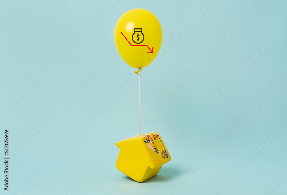 Inflation symbol. A yellow house-shaped piggy bank lifted by a yellow ...