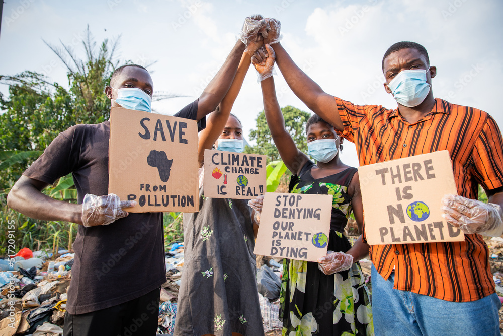 Four young adults protest with signs against pollution outside an ...