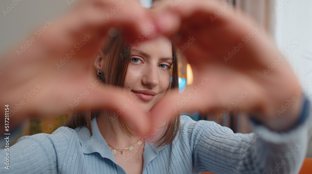 I love you. Young woman makes symbol of love, showing heart sign to ...