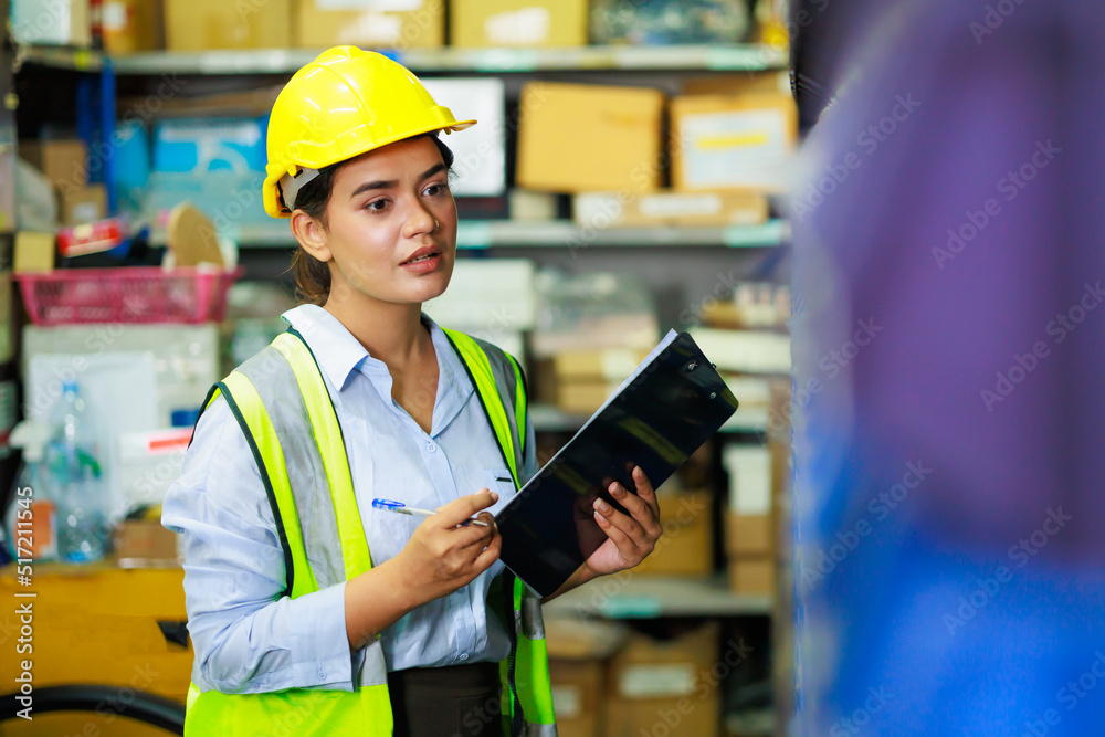 Happy female factory manager checking order on cardboard in industrial ...