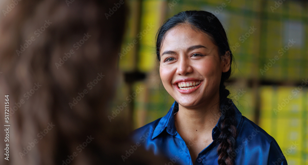 Happy female factory manager checking order on cardboard in industrial ...