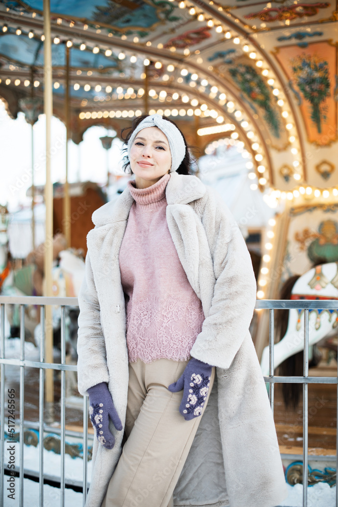 A beautiful young woman in a faux fur coat and snake clothes poses next ...