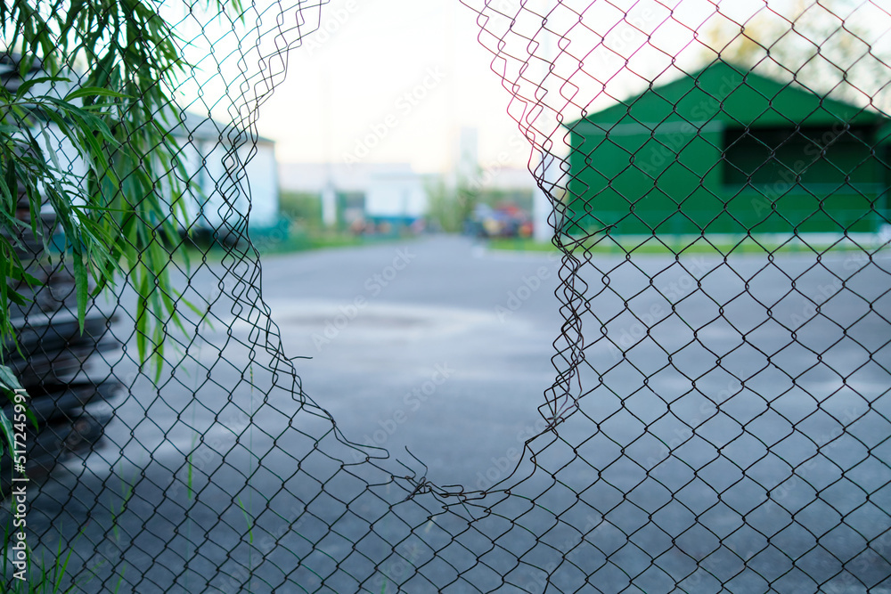 Hole in the fence. Mesh wire boundary. Steel mesh barrier fence. Chain ...