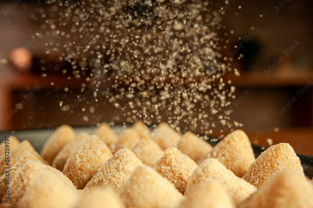 Breading brazilian croquette (coxinha de frango) on bricks wall ...