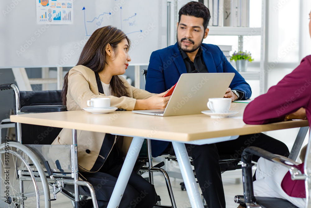 Millennial Indian male businessman manager mentor in formal suit talking helping disabled ...