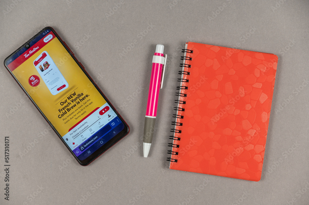 Foto de Red notepad, pen and smartphone on gray. Tim Hortons' lead page ...