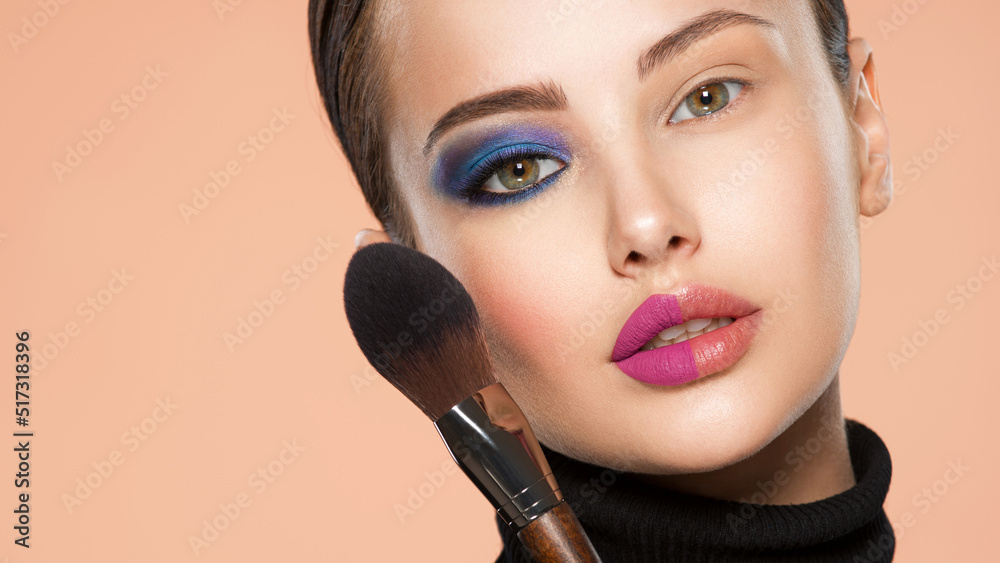 Portrait of a girl with cosmetic brush near face. Woman making makeup ...