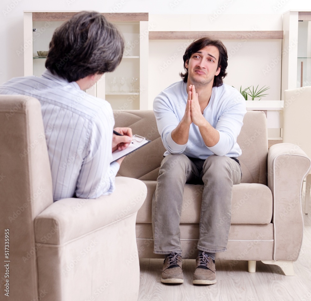 Young male patient discussing with psychologist personal problem Stock ...