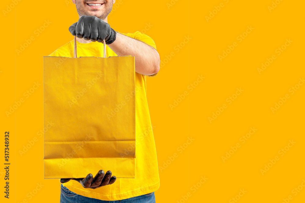 Delivery man with paper bag. Courier in uniform t-shirt, gloves service ...