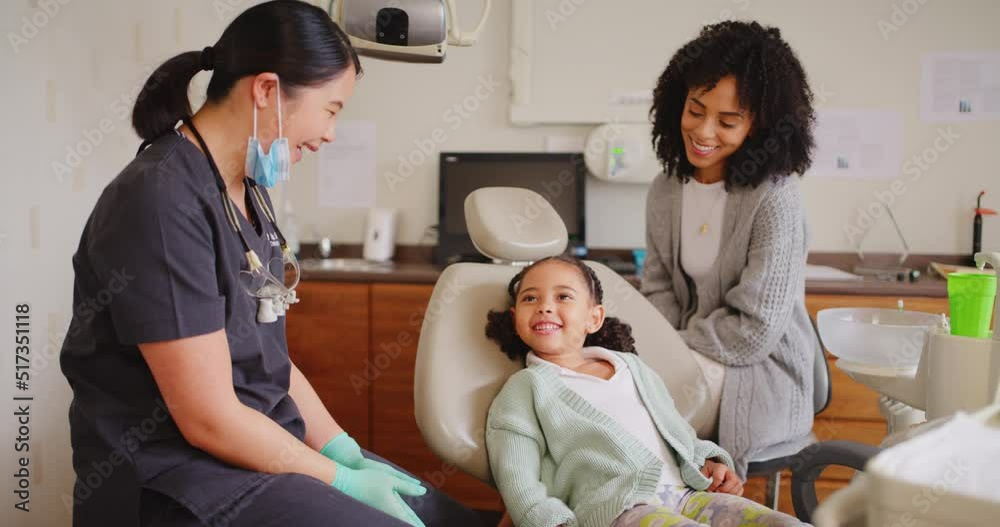 Dentist and child giving high five during fun dental appointment. Mom ...