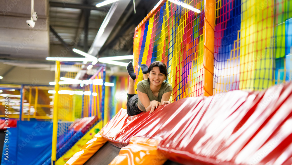 Pretty girl lying on colorful trampoline at playground park and smiling ...