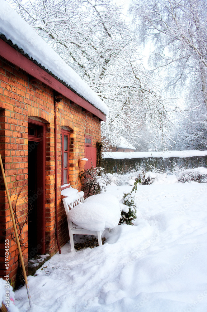 Quiet old house in snow landscape and frozen garden. A red brick ...
