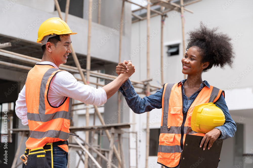Mechanical Engineer team shaking hands while working on construction ...