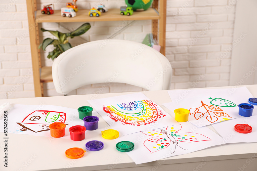 Cute children's drawings and set of paints on white table in room Stock ...