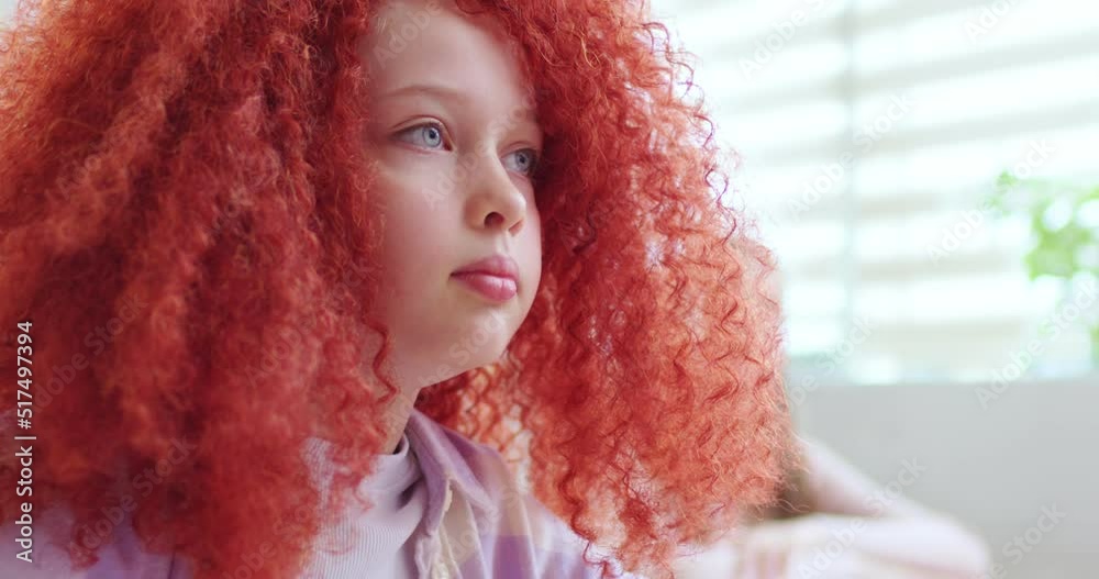 Close up of face of cute small clever schoolgirl with red curly hair ...