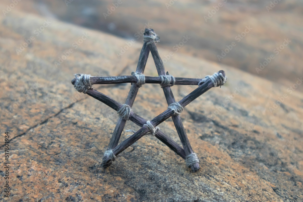 Pentagram made of small wood sticks on stone background. Esoteric and ...