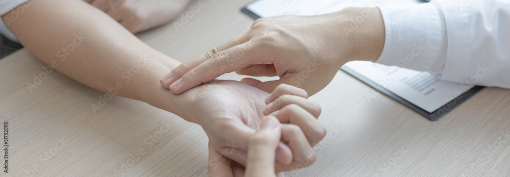 Medical professional measures the pulse of a male patient's wrist to ...