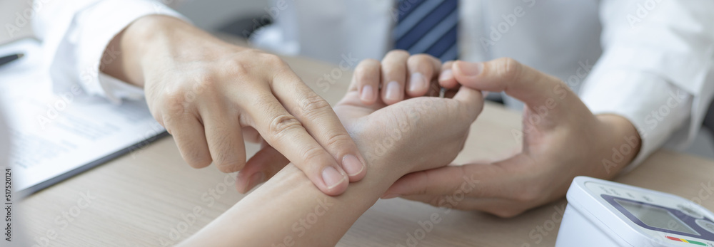 Medical professional measures the pulse of a male patient's wrist to ...
