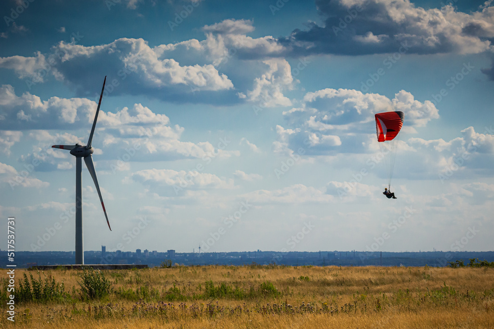 wind turbine in the sky, paraglider flying Stock Photo | Adobe Stock