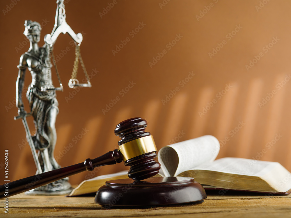 Judgment and Justice. A judge's gavel, an open book and a bronze statue ...