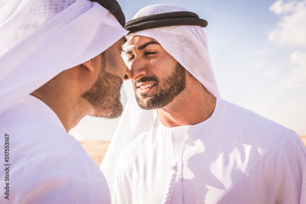 Arabic men in the desert of Dubai wearing traditional emirates clothing ...