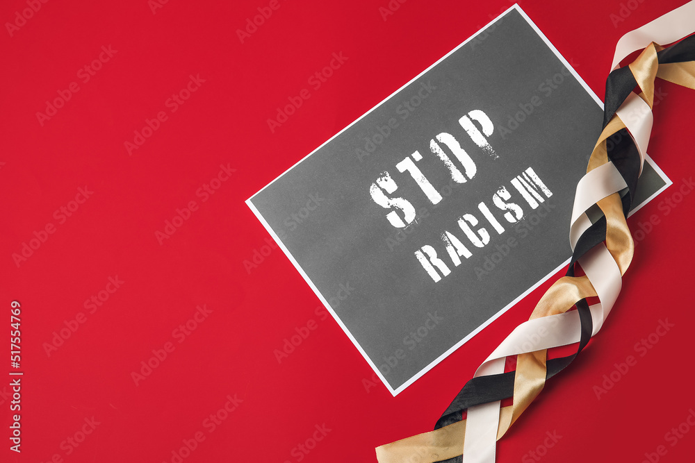 Braided ribbons and paper sheet with text STOP RACISM on color ...