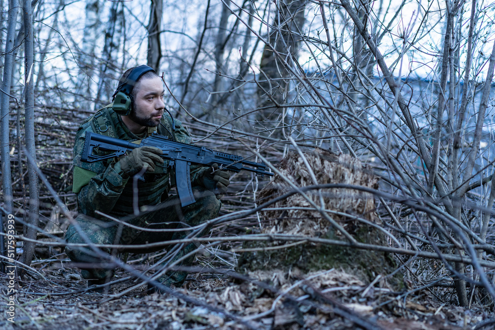 soldier in the forest. a man in military uniform in the branches of ...
