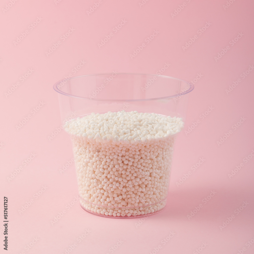 Disposable plastic cup with tapioca pearl on pink background. White ...