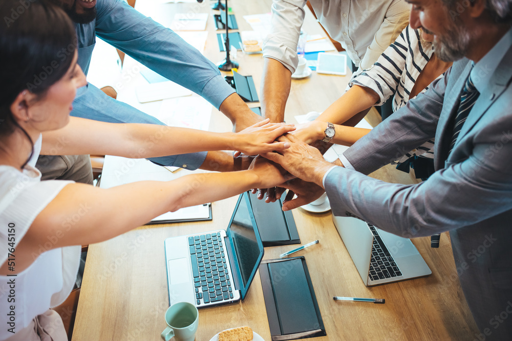 Group of business workers standing with hands together at the office ...