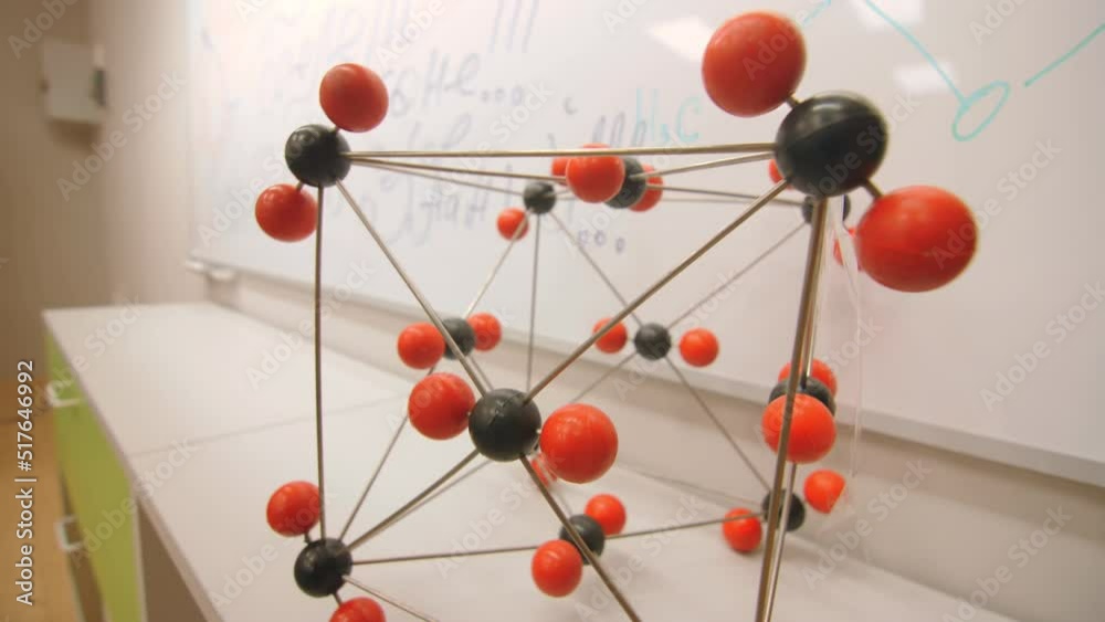 Molecule model made of plastic balls and wires against board with ...