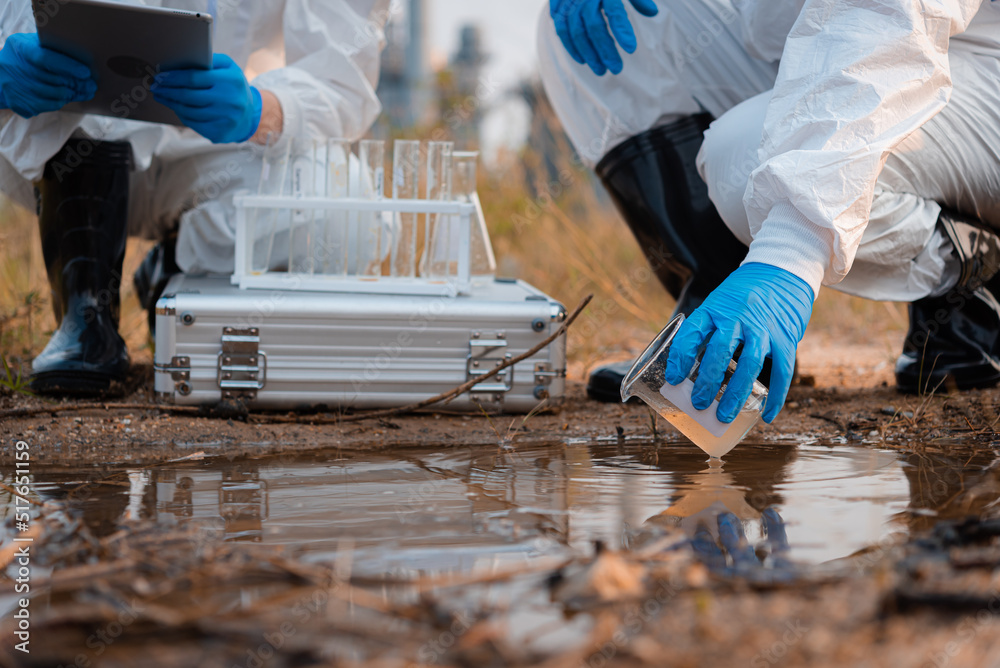 Ecologist taking samples of water with test tube from city river to ...