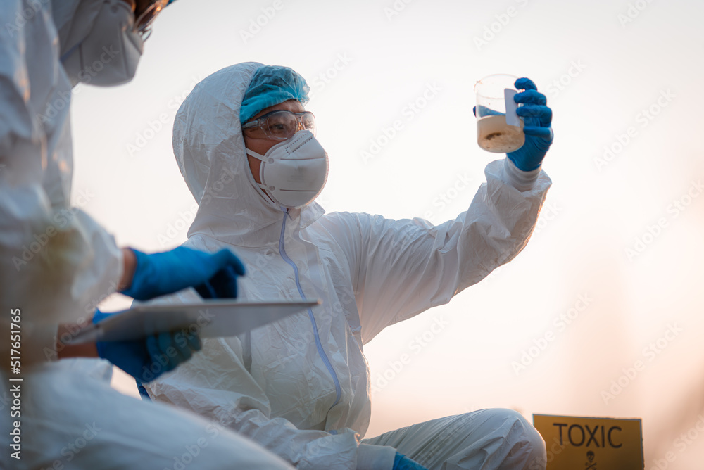 Ecologist taking samples of water with test tube from city river to ...