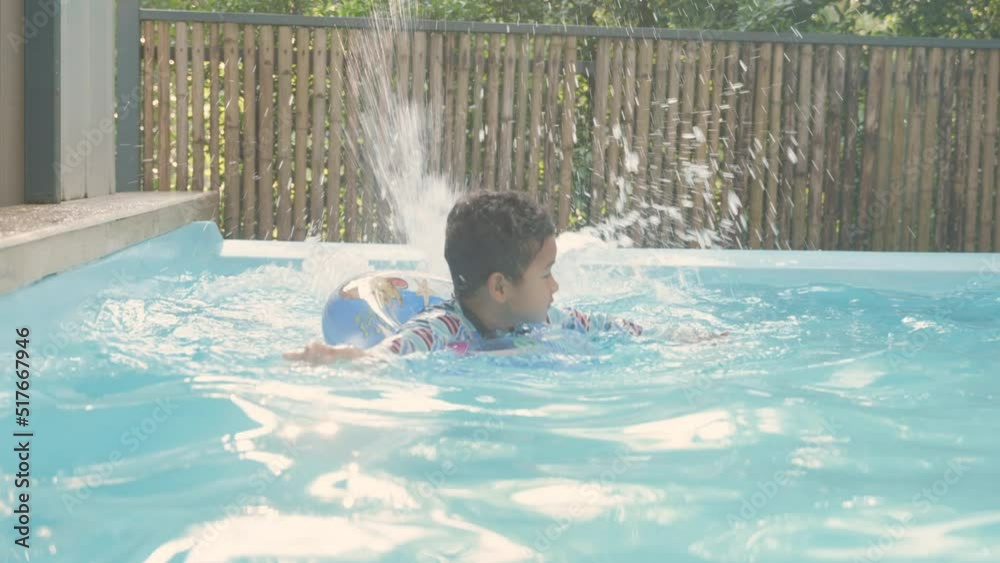 Happy young boy curly hair on inflatable ring having fun in water and ...