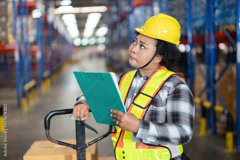 Worker working in large warehouse surrounding with high level of ...