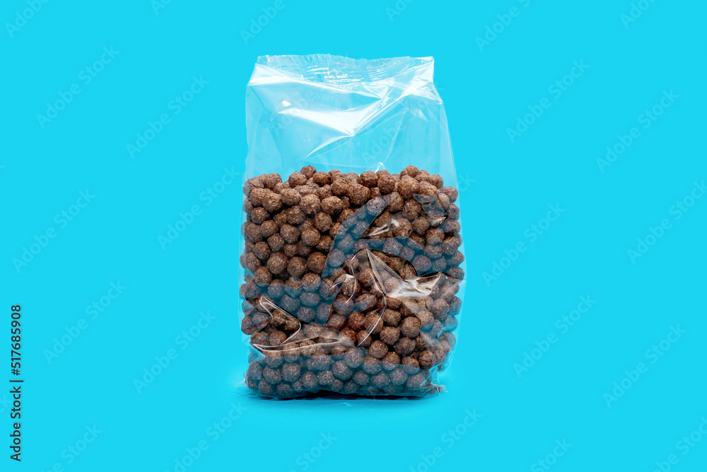 Round chocolate flakes in a transparent package on a blue background ...