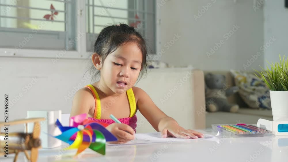 Child little girl drawing cartoon on paper before paint the color ...