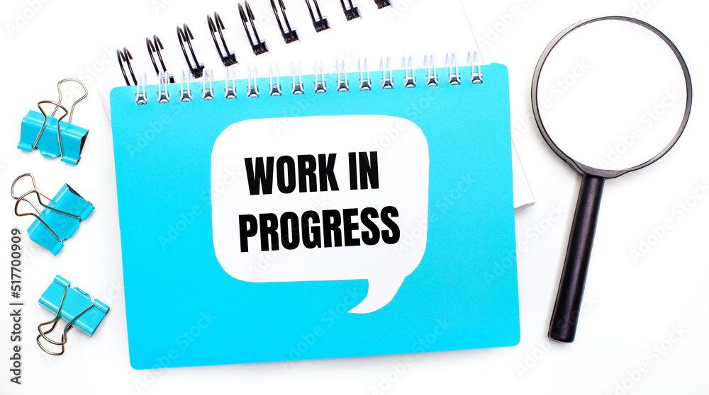 Office table with blue notepad, paper clips, magnifying glass and white ...