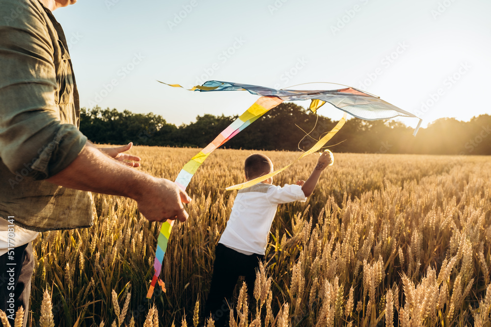 Happy father and son flying kite in the field at sunset Stock Photo ...