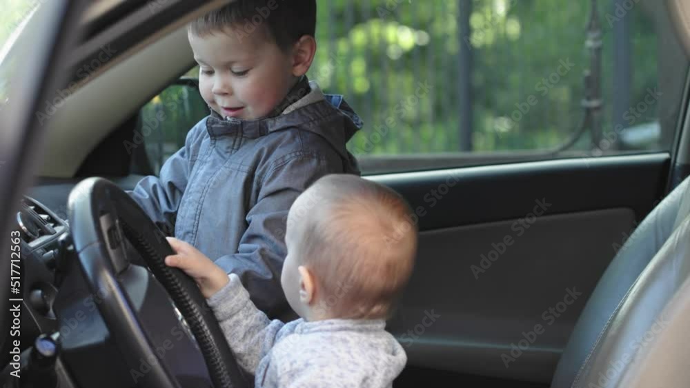 two brothers boys playing inside car, driving, steering wheel, have fun ...