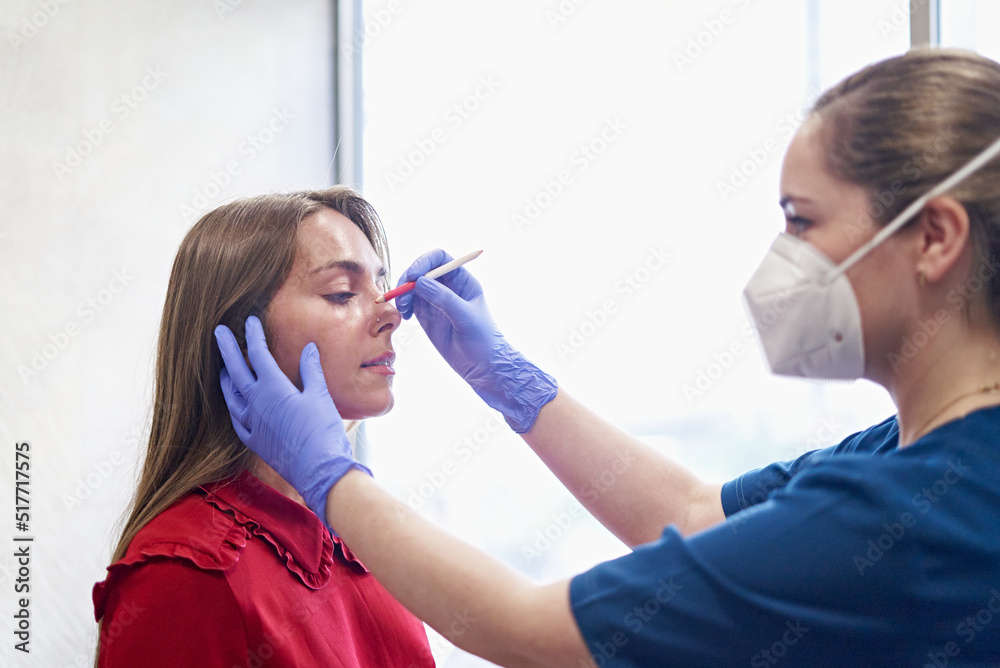 Esthetician correcting eyebrows of client Stock Photo | Adobe Stock