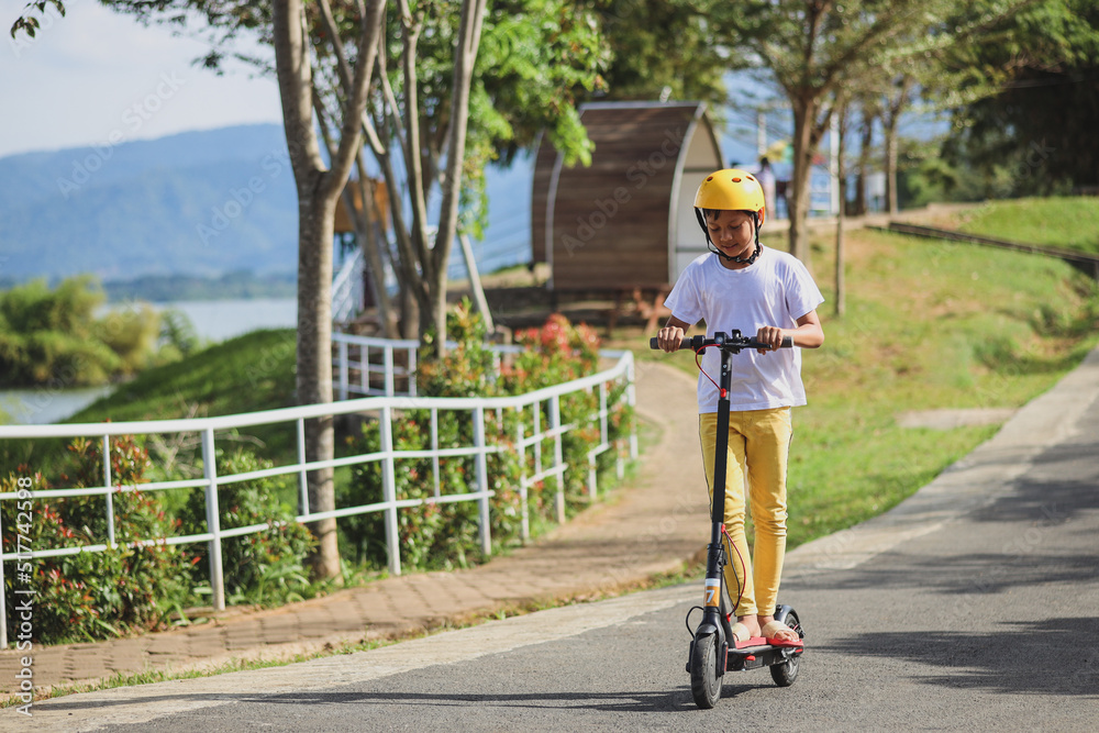Portrait of little Asian boy wear helmet enjoy having fun riding ...