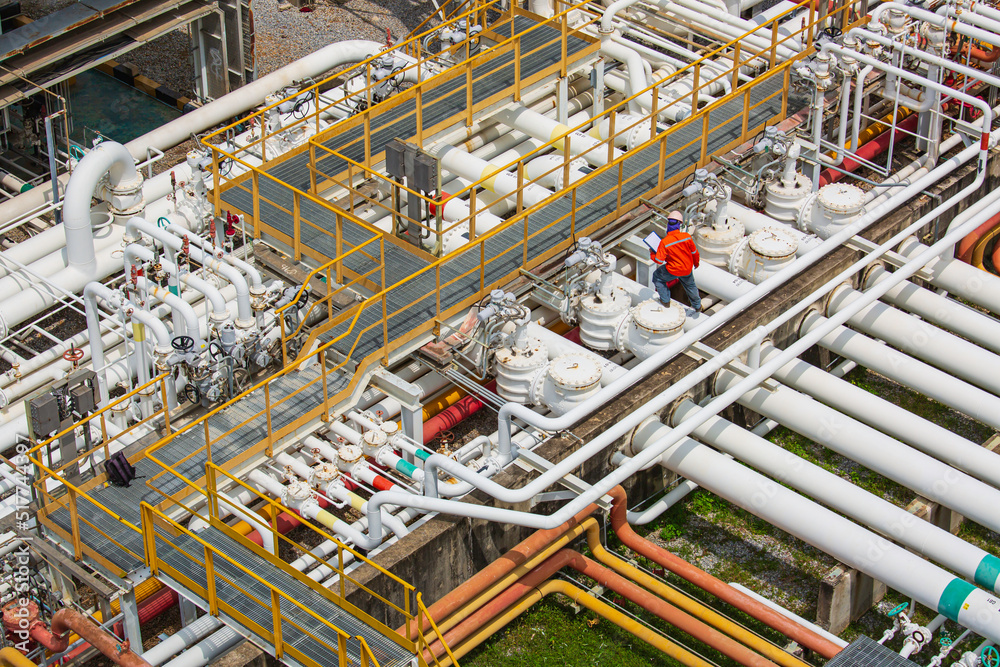 Male worker inspection at steel long pipes and pipe elbow in station ...