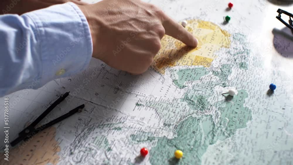 Tourist's hand shows hiking route on map, map with travel markers ...