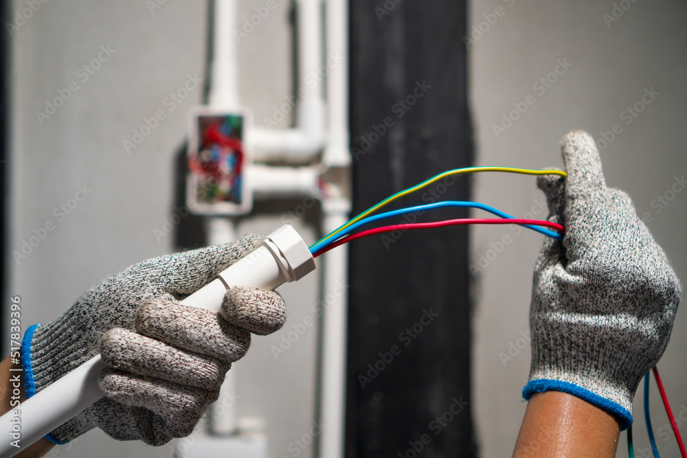 Electrician pulling wire into PVC Conduit Stock Photo | Adobe Stock