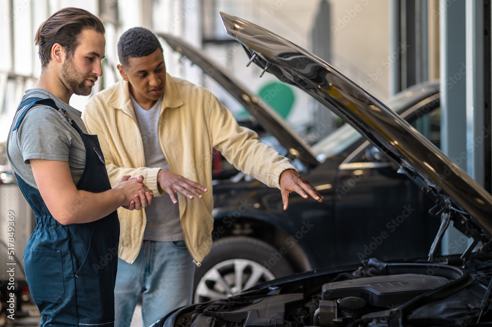 Mechanic looking into hood and customer telling problem Stock Photo ...