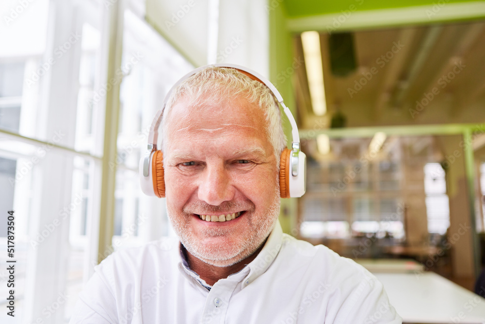 Elderly man with headphones smiles while listening to music Stock Photo ...