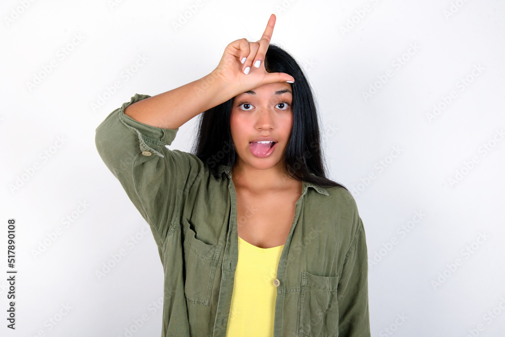young brunette woman wearing green overshirt standing against white ...